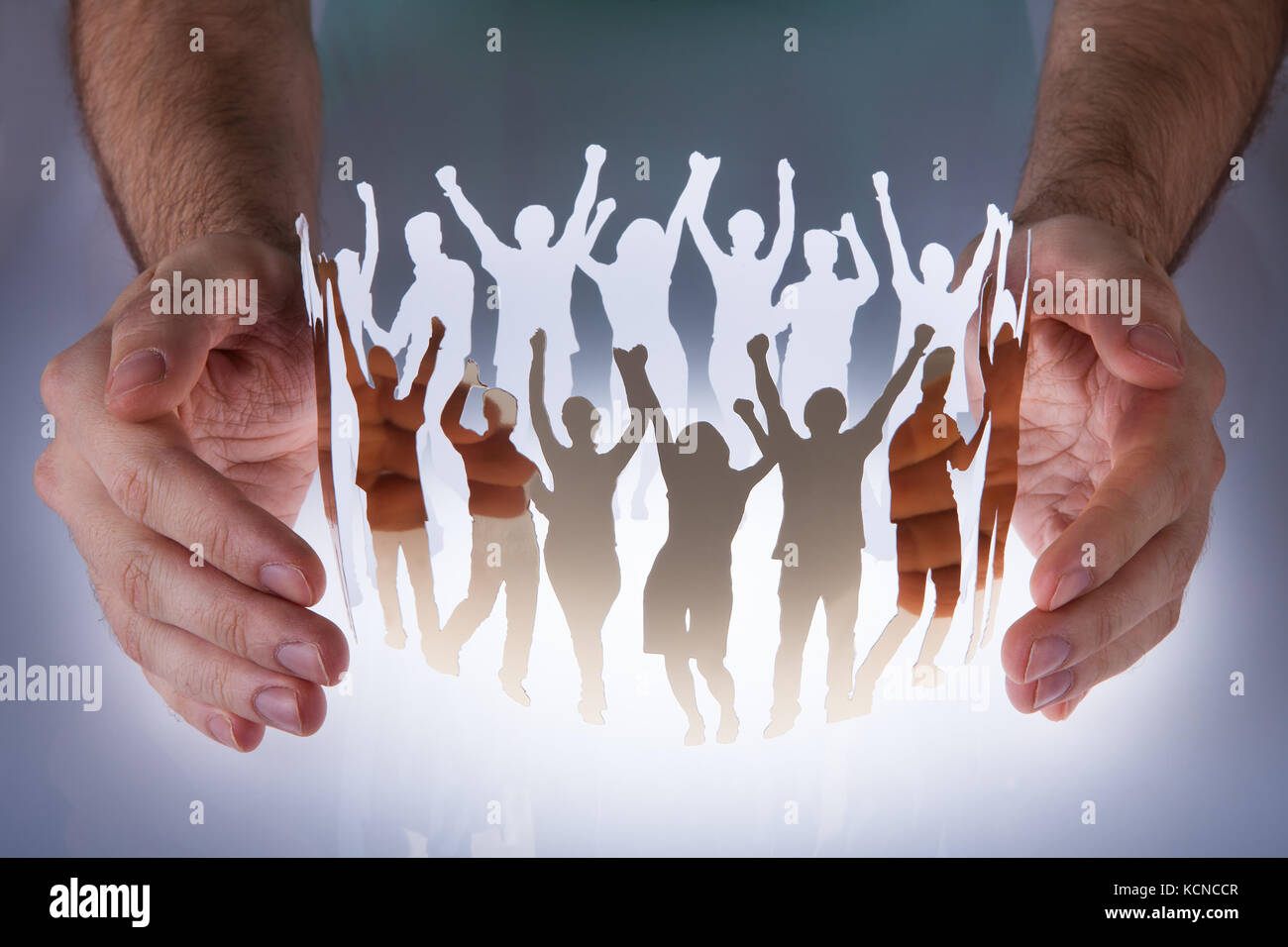 Close-up Of Hands Taking Care Of Paper Cut Out Of Human Figure Stock ...