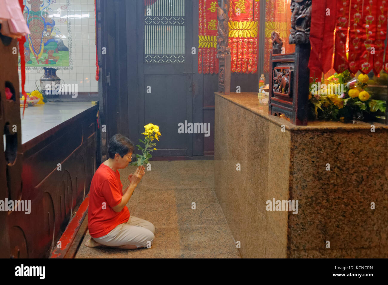 woman praying inside a chinese temple during new year celebrations in ...