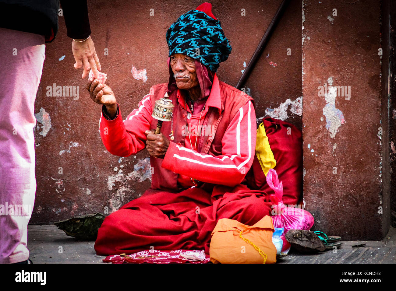 A beggar in Kathmandu receiving alms from a passerbypraye Stock Photo ...