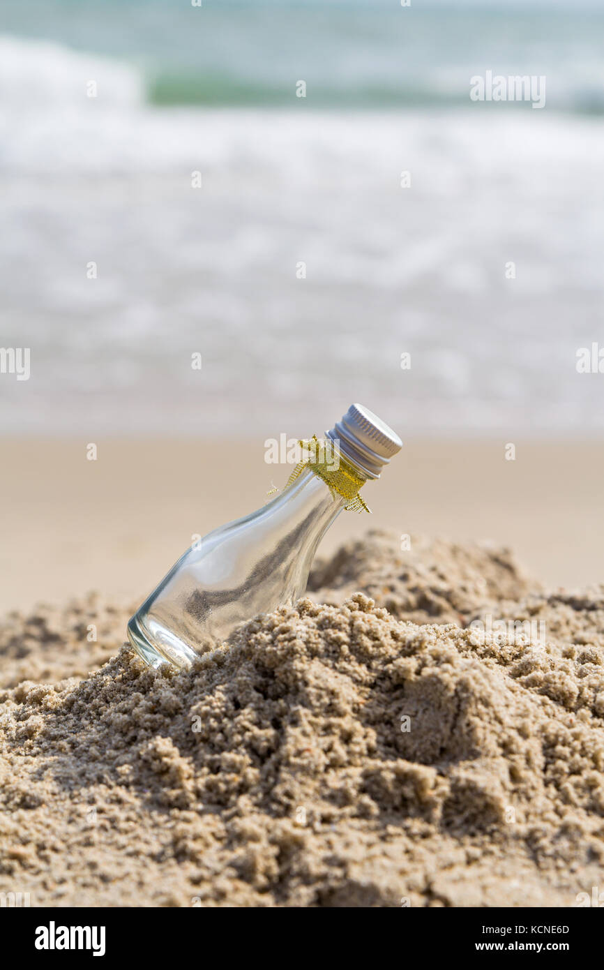 Empty glass bottle on the beach Stock Photo - Alamy