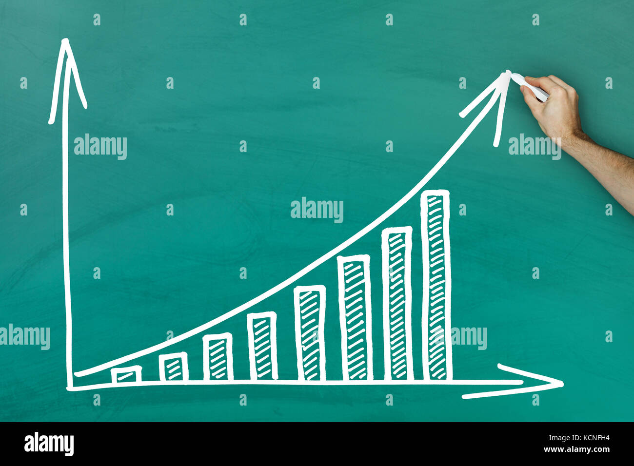 Hand holding chalk writing profit growth chart on green blackboard ...