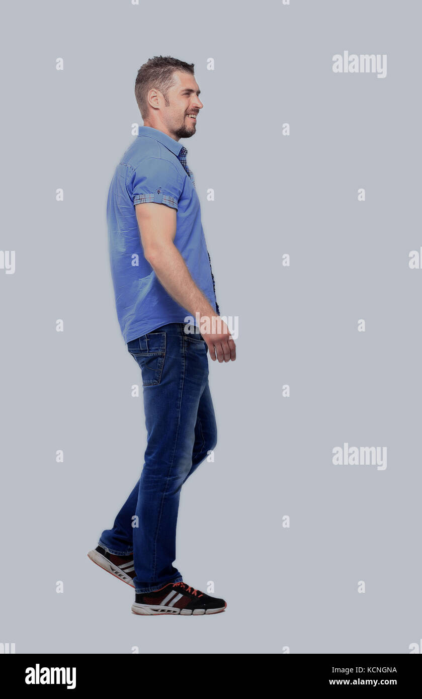 side portrait of young man walking in isolated studio background Stock ...