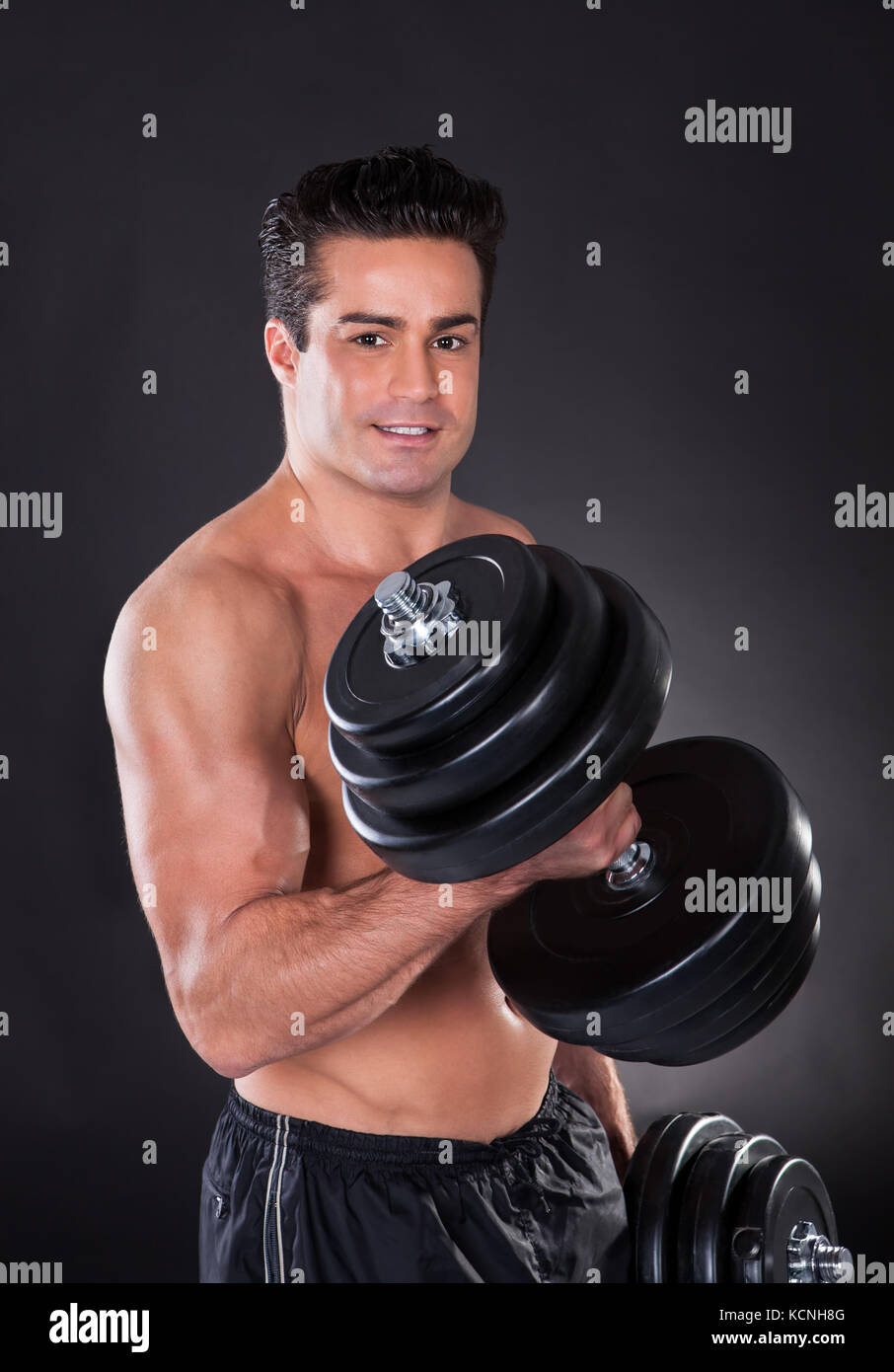 Portrait Of Young Man Working Out With Dumbbells Stock Photo - Alamy