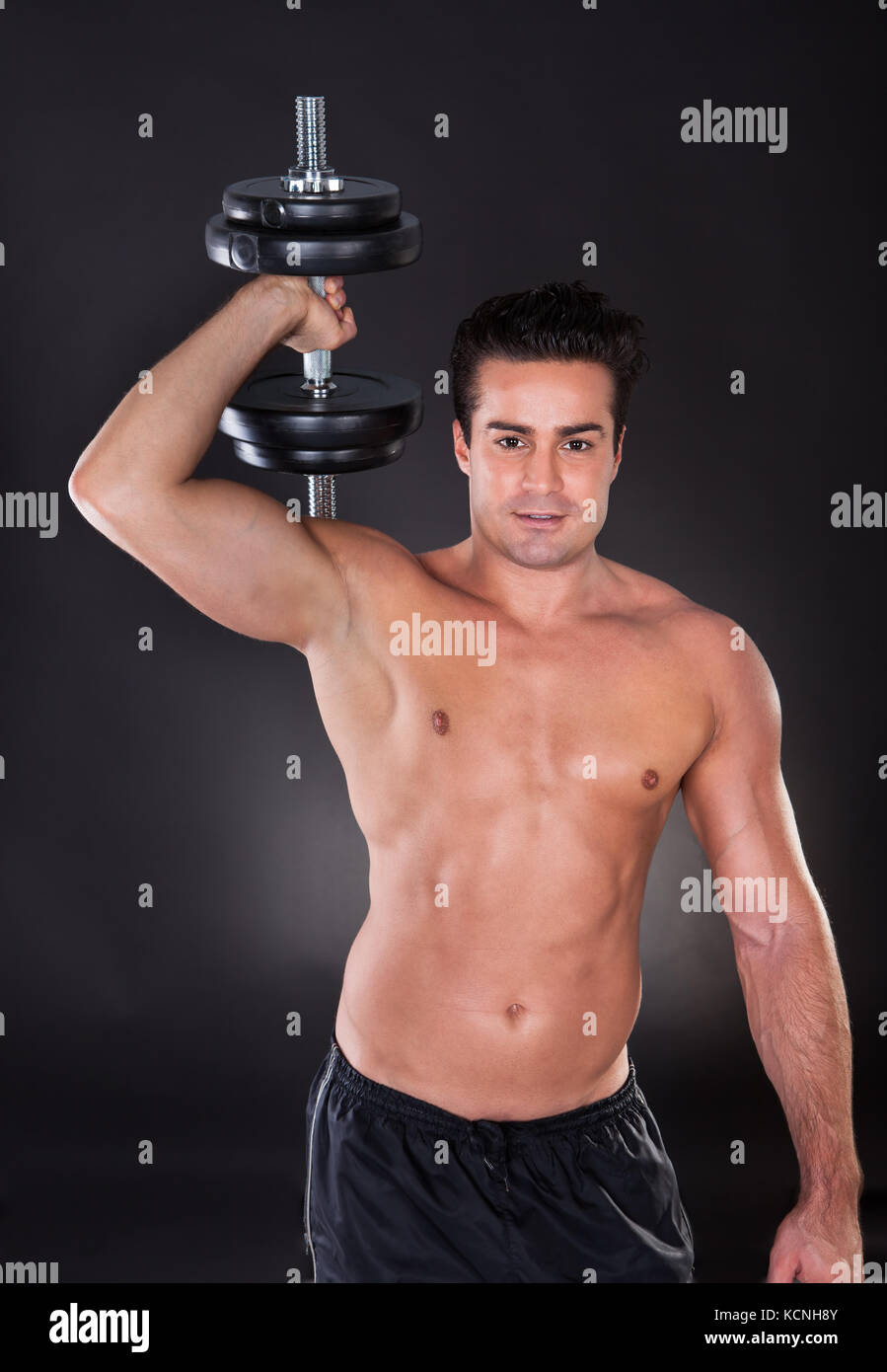 Young Muscular Man Exercising With Dumbbells On Black Background Stock ...