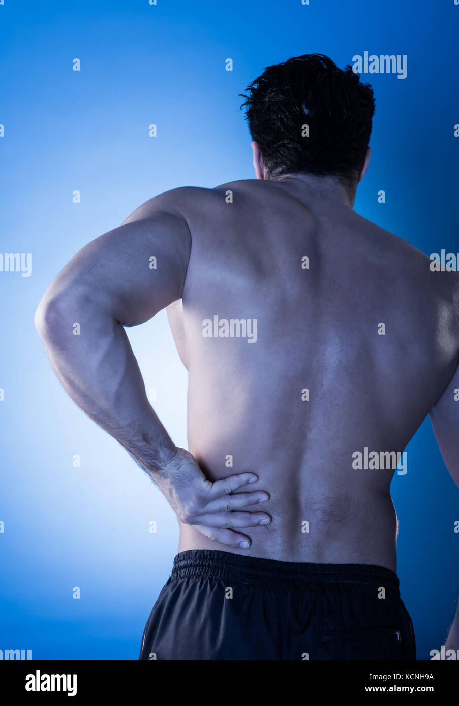 Rear View Of Young Man Suffering From Back Pain Stock Photo - Alamy