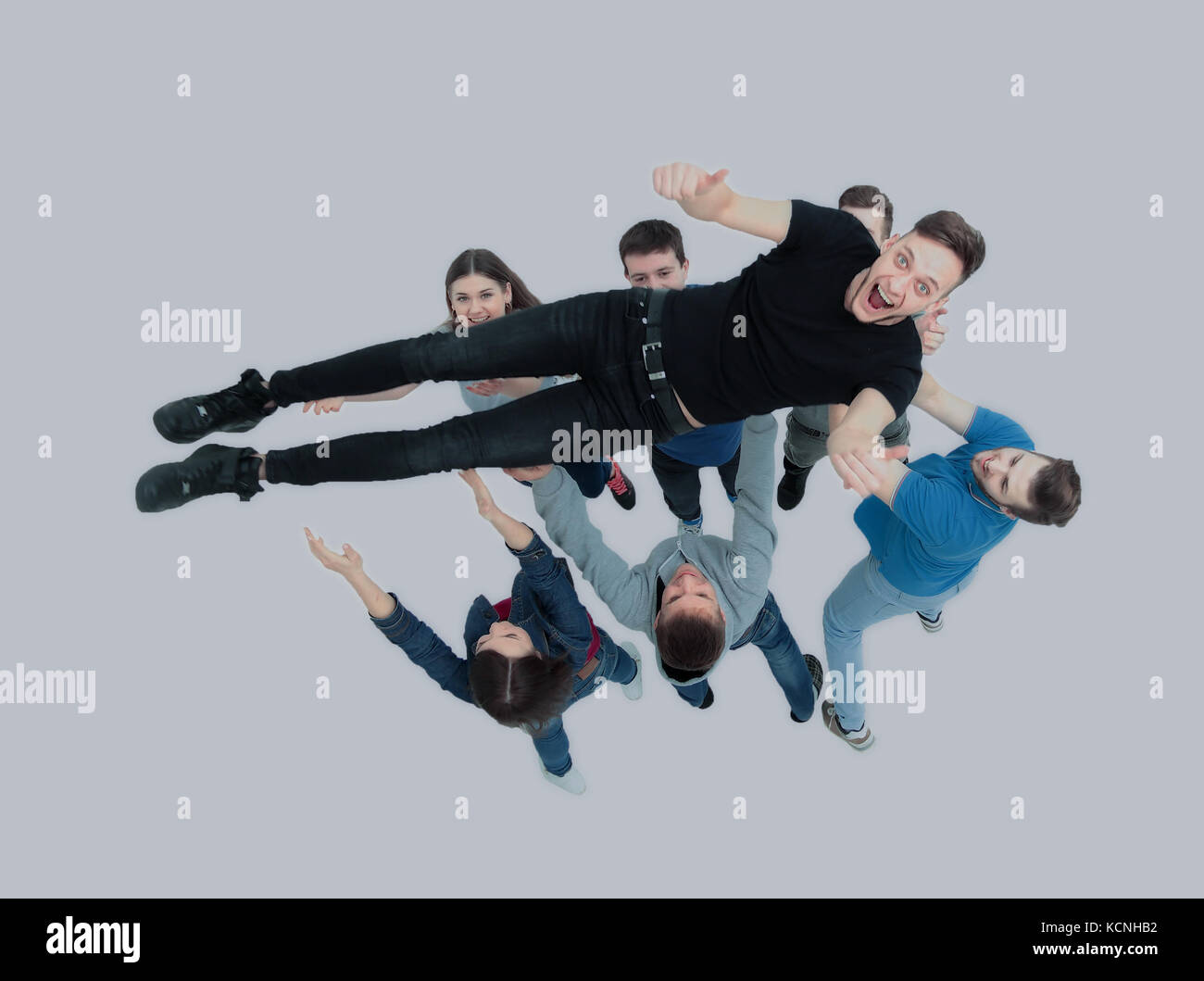 group of young people rocking in the hands of the leader of the team in ...