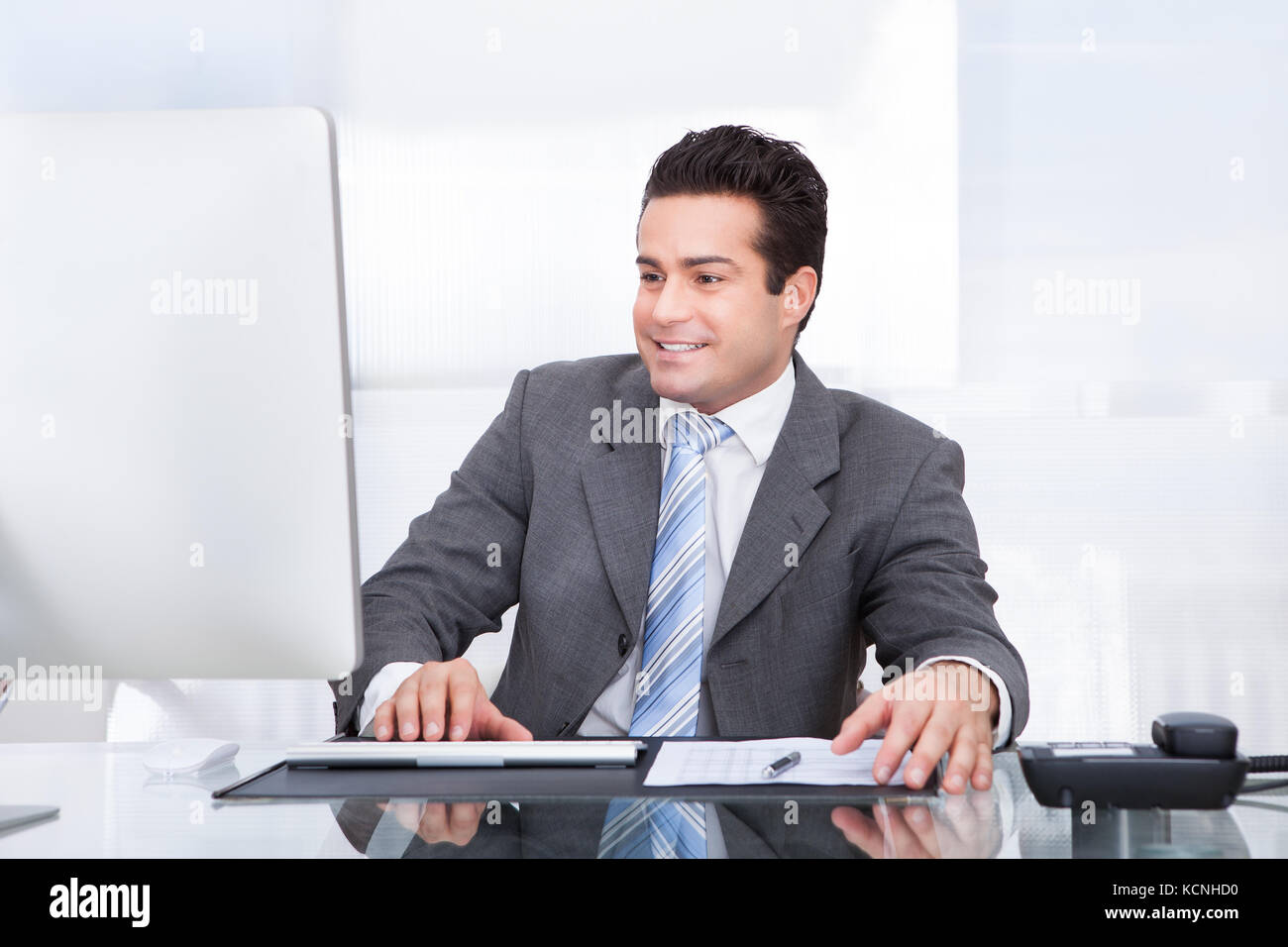 Portrait Of Young Businessman Using Computer At Office Stock Photo - Alamy
