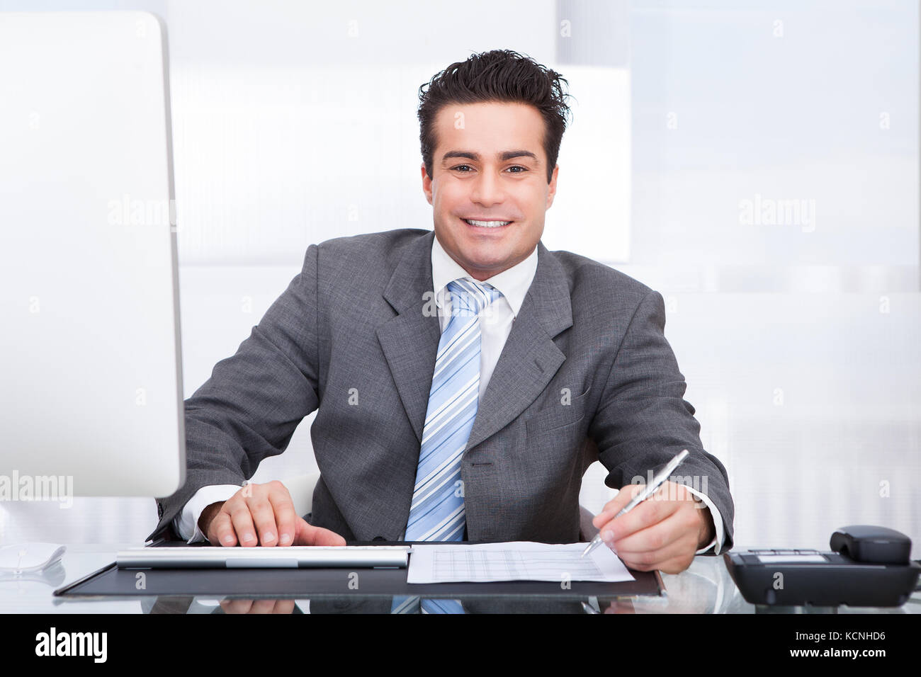 Portrait Of Young Businessman Using Computer At Office Stock Photo - Alamy