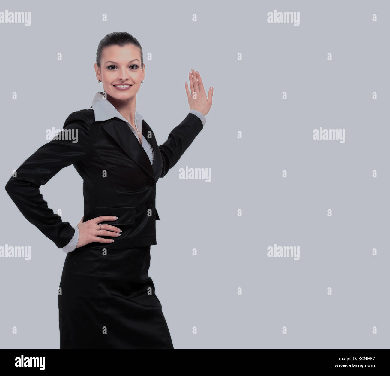 Smiling business woman points to advertise on the wall Stock Photo - Alamy