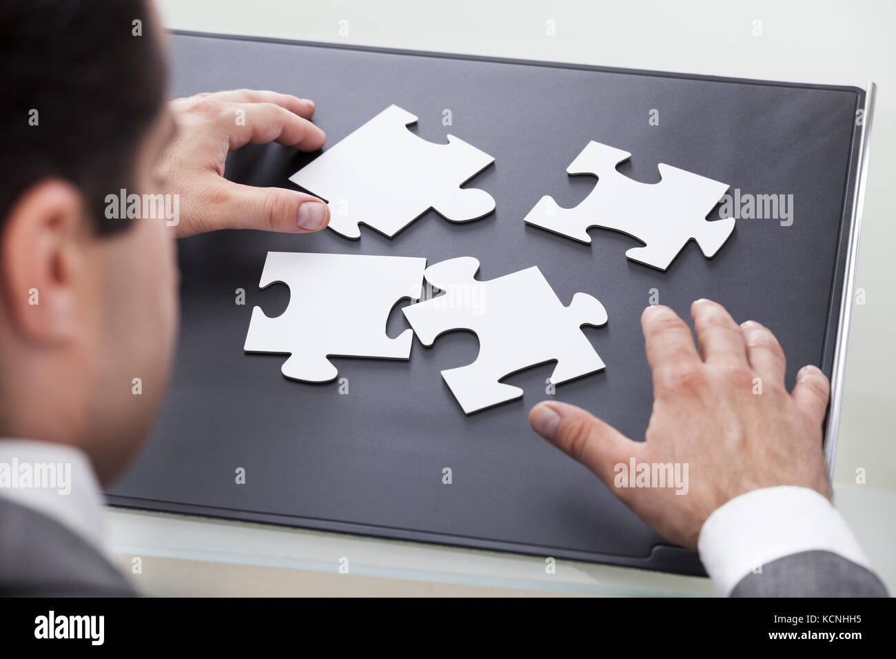 Close-up Of A Businessman Solving Jigsaw Puzzle Stock Photo - Alamy
