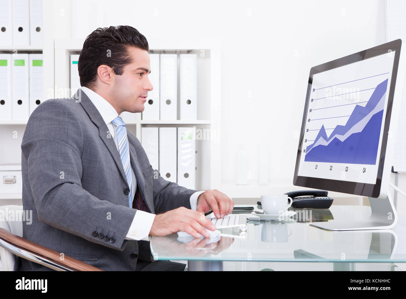 Portrait Of Young Businessman Using Computer At Desk Stock Photo - Alamy