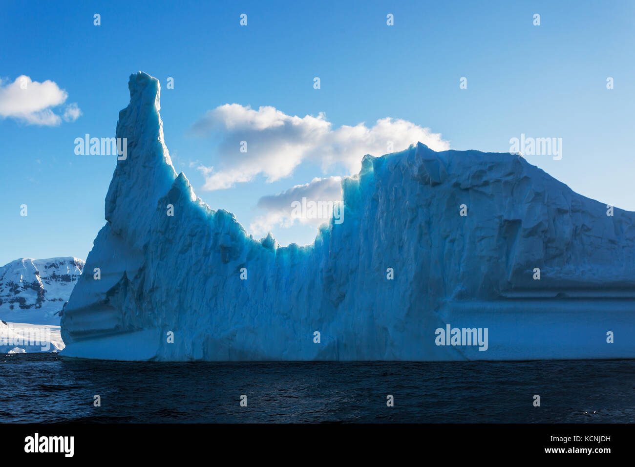 A backlit iceberg floats in water near Anvers Island, Antarctic ...