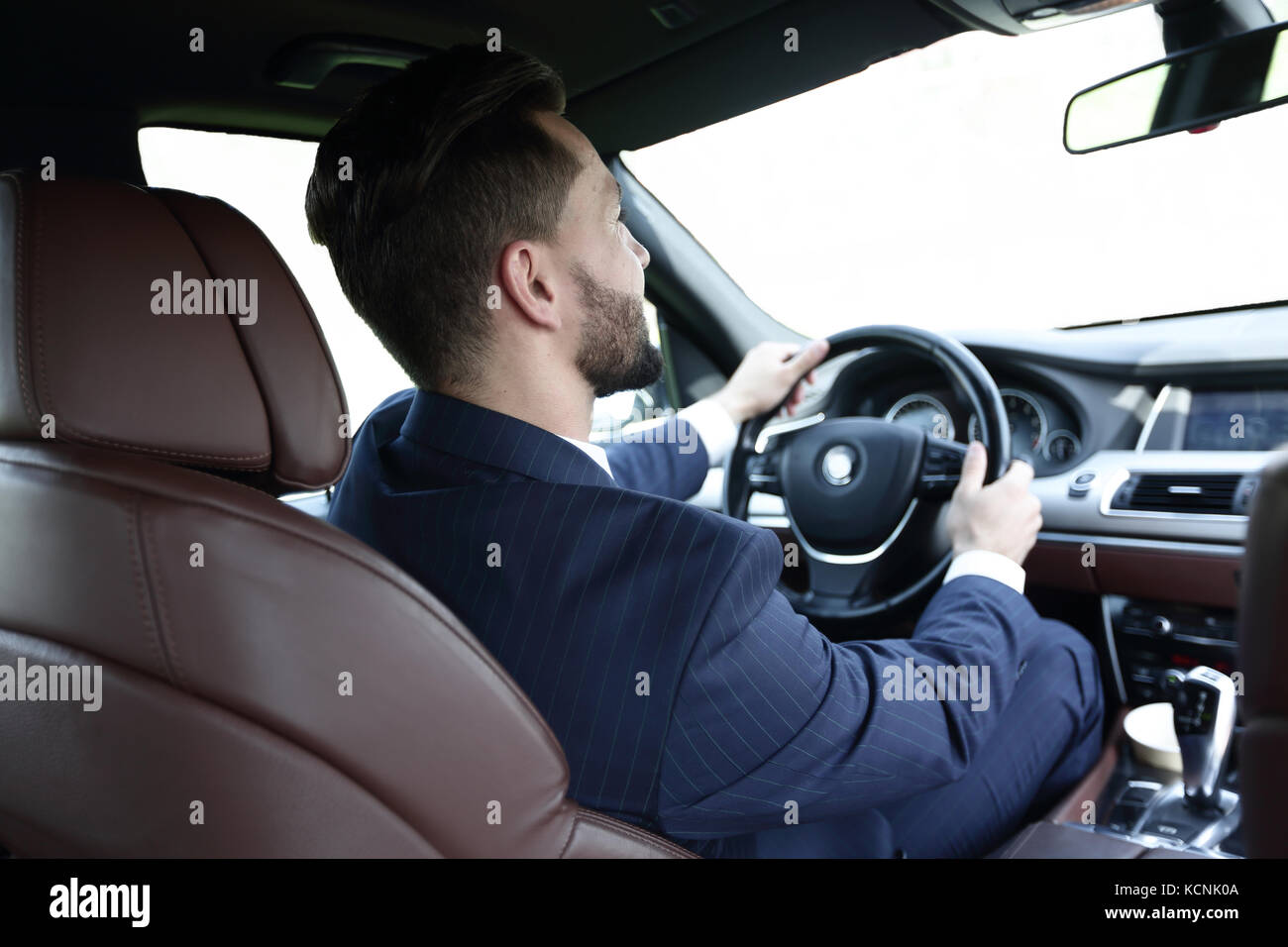 businessman sits at the wheel in his car and looks at the road Stock ...