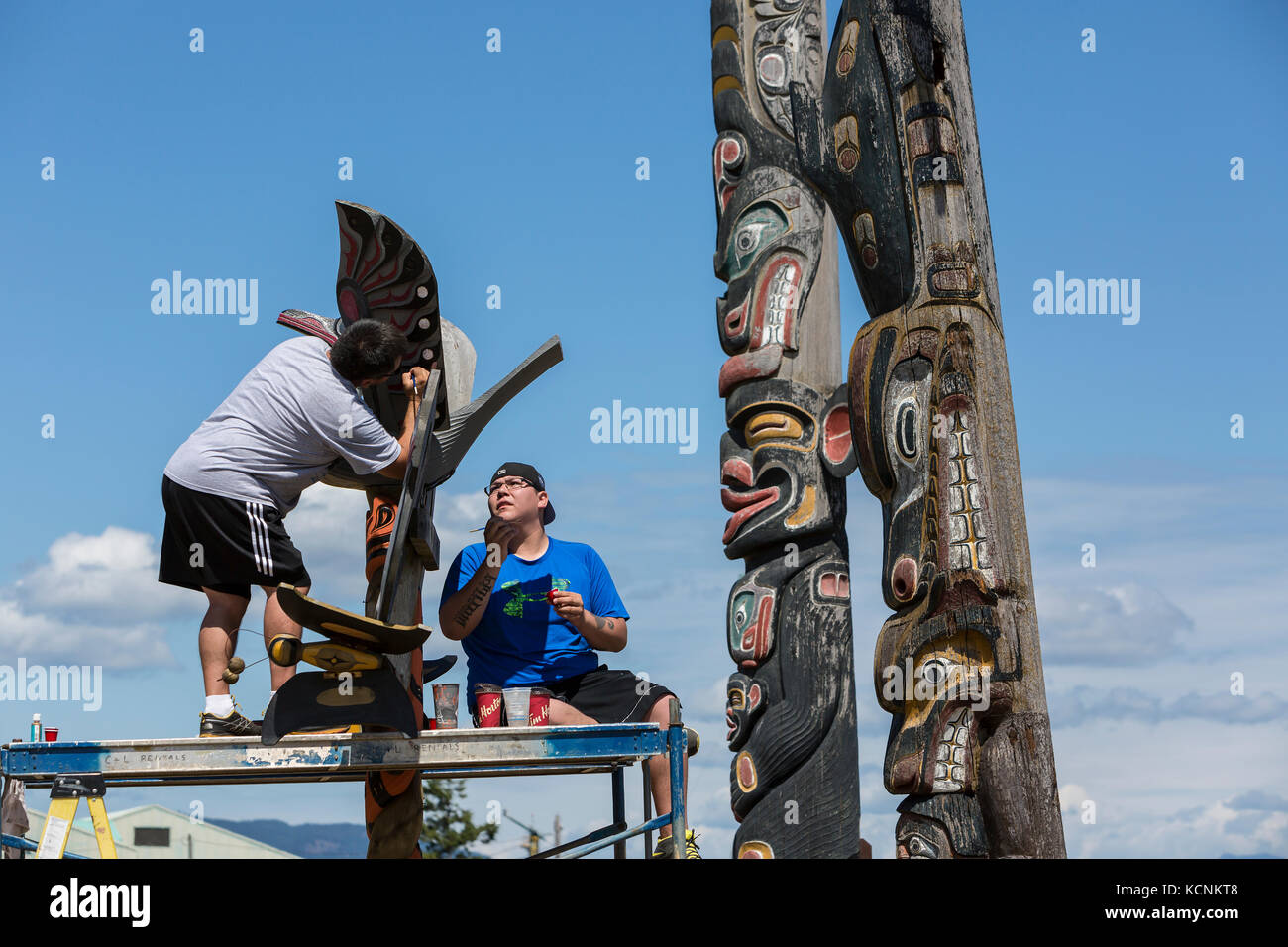 Two first nations family members refurbish a relatives memorial pole ...