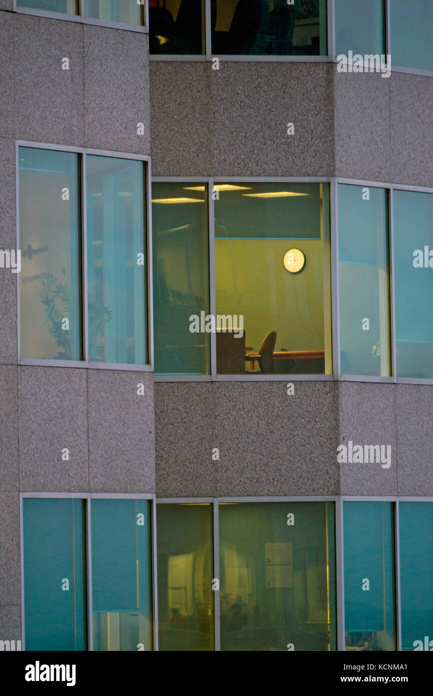 Clock in a window of an office building at night Stock Photo - Alamy