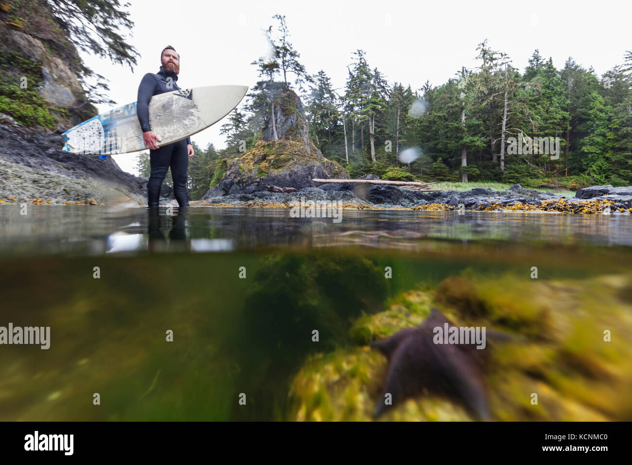 A surfer in his watery element looks to the surf break amidst a low ...