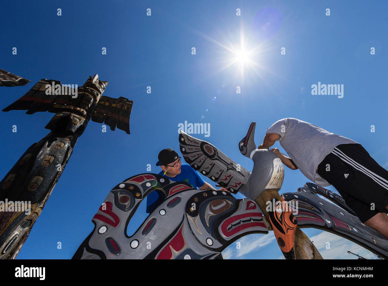 Family members refurbish a mortuary pole at the gravesite of a family ...