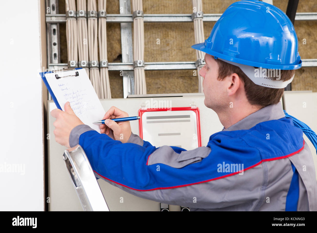 Portrait of young construction worker writing on clipboard Stock Photo ...