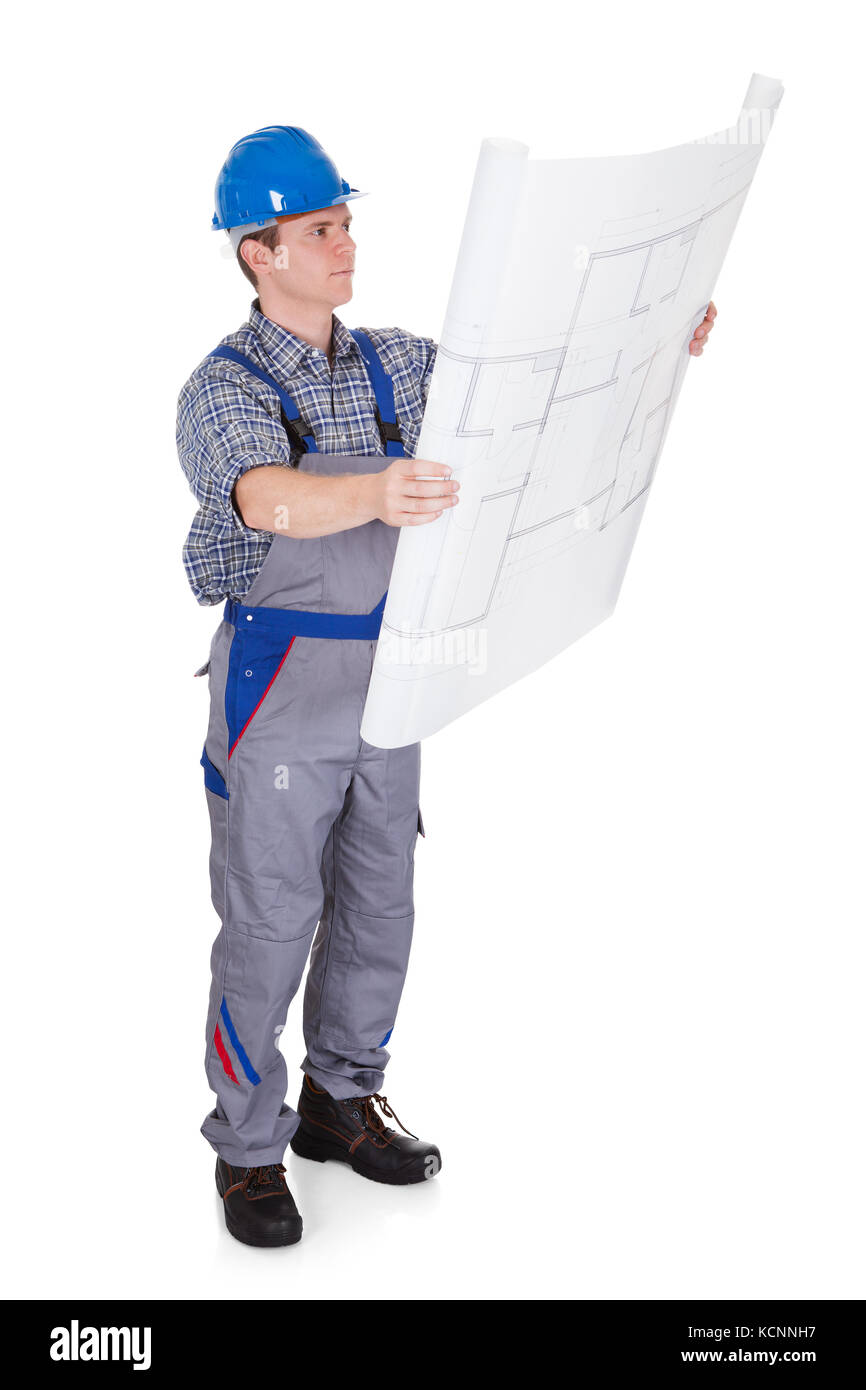 Male construction worker looking at blue prints isolated on white ...