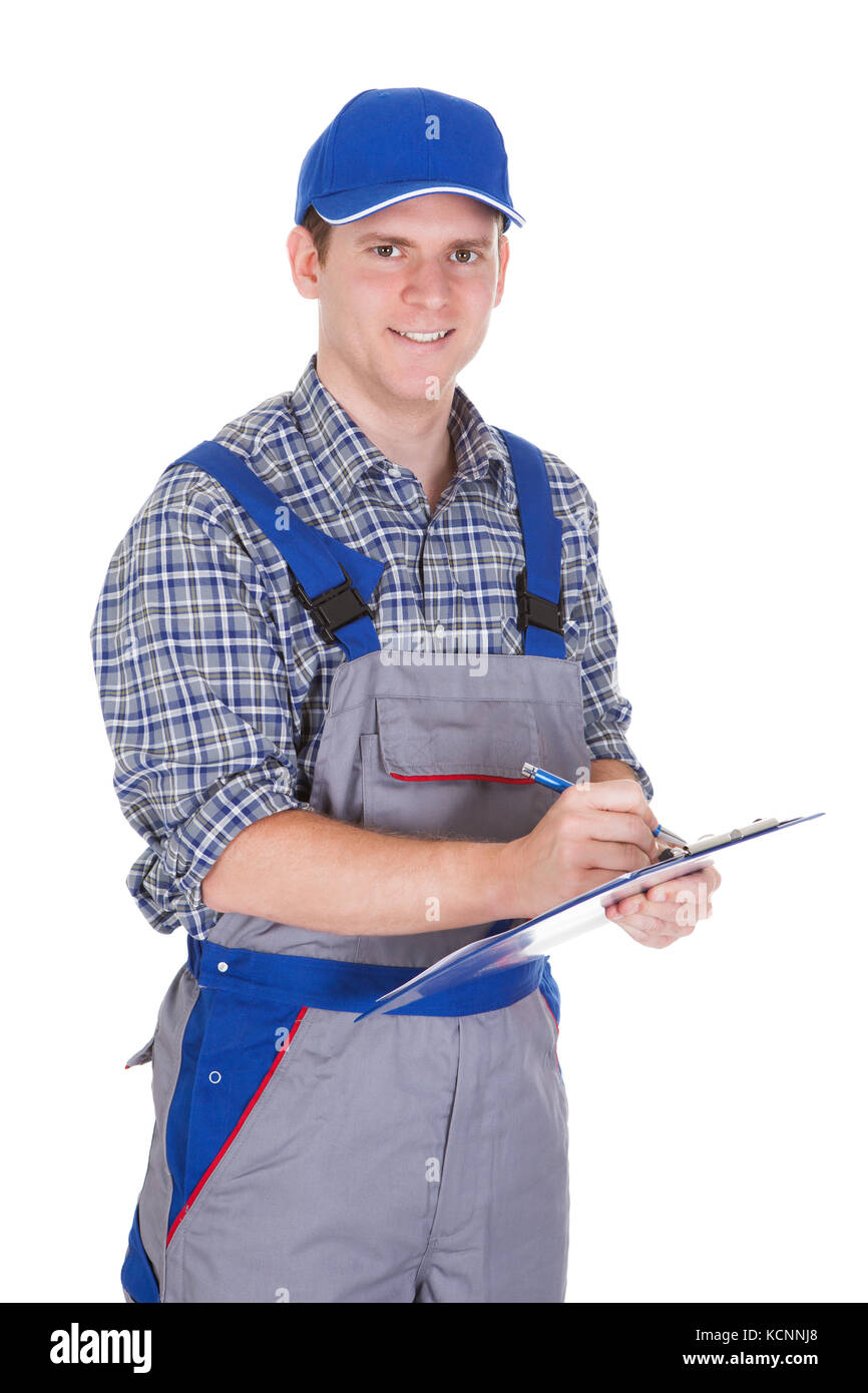 Young construction worker writing on clipboard isolated on white ...