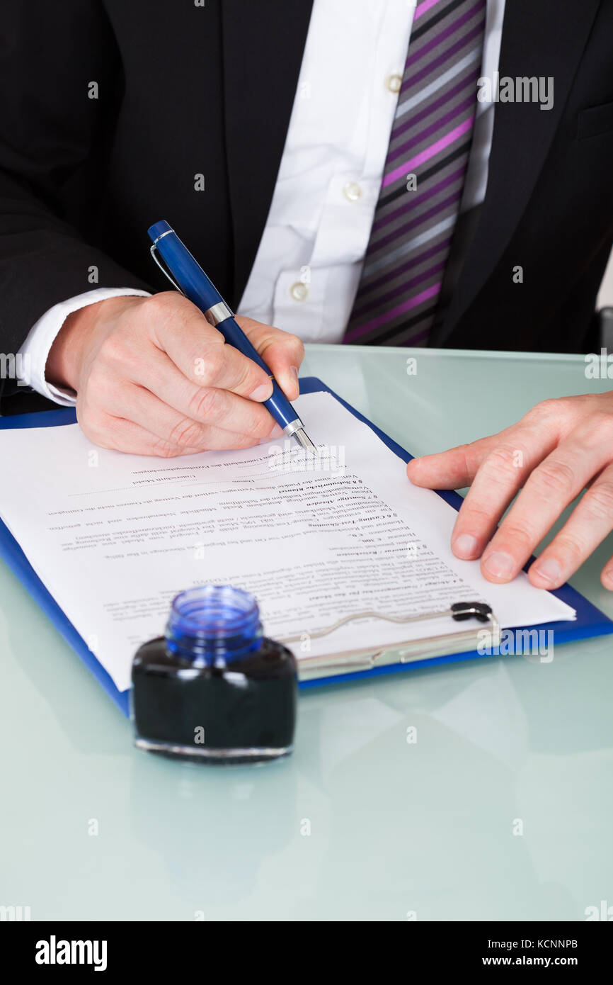 Close-up Of Businessman Hand Writing With Ink Pen Over Document Stock ...