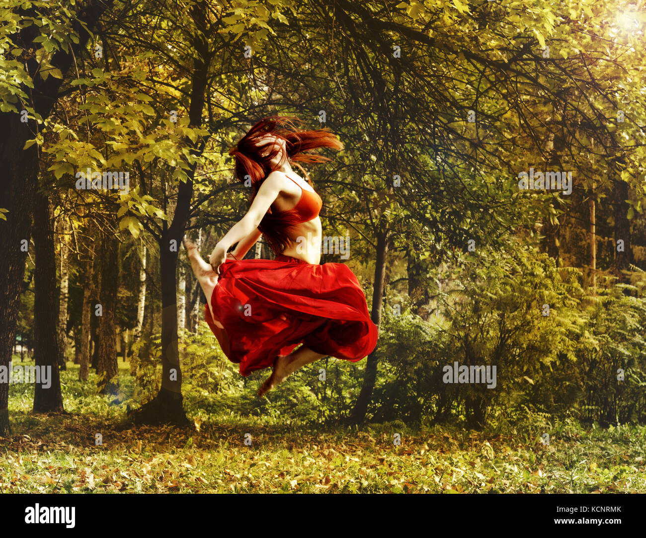 redhead beautiful woman in red dress dancing in a autumn forest Stock ...