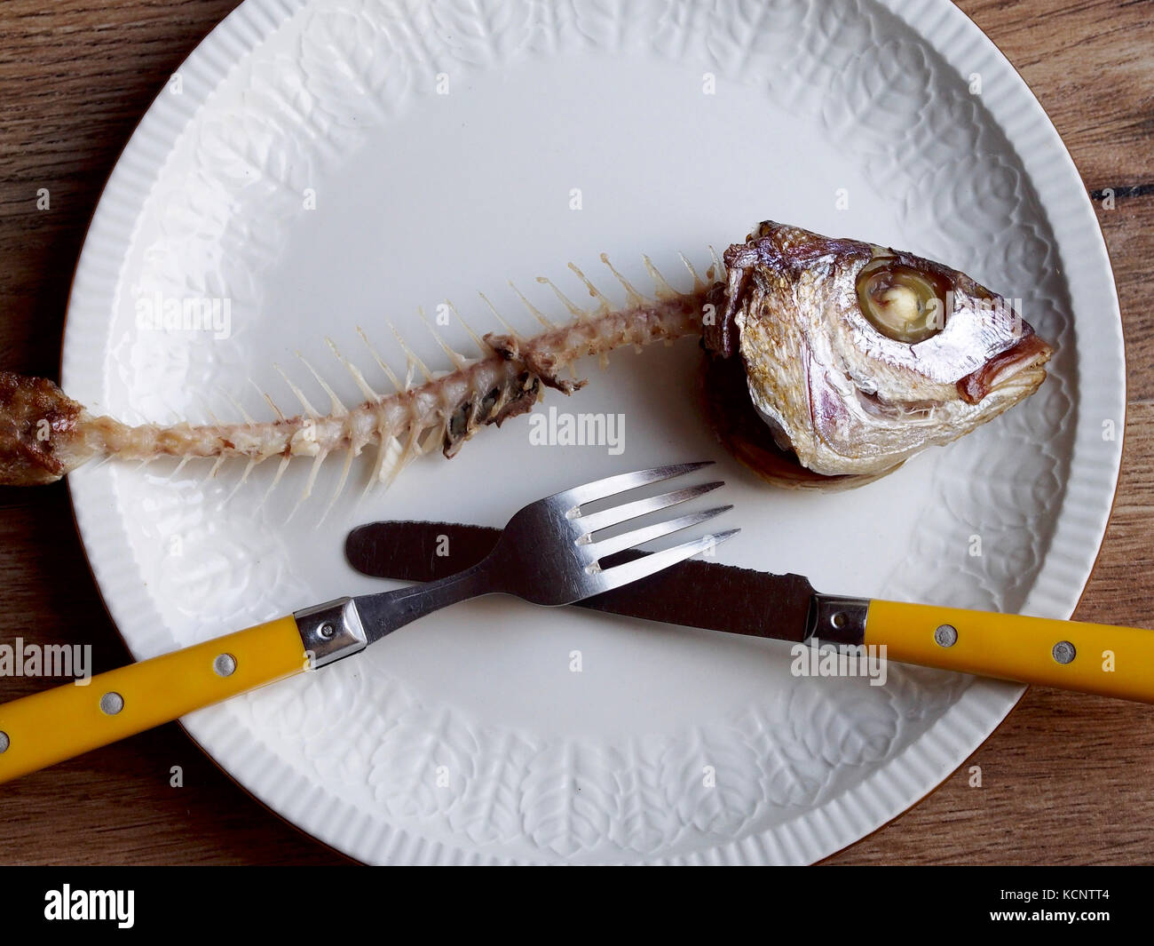 Fishbone with fork and knife in a beautiful plate Stock Photo - Alamy