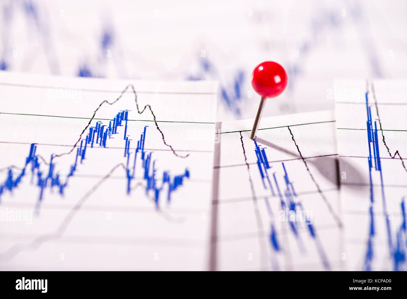 Diagrams show stock prices, one is marked with a pin Stock Photo - Alamy