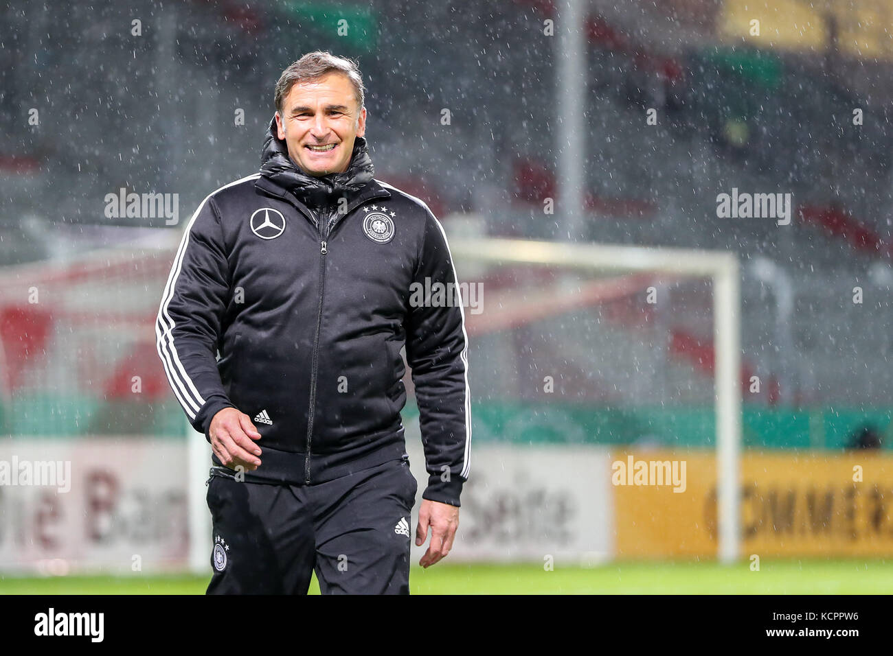 German head coach Stefan Kuntz arriving to the field under the rain ...