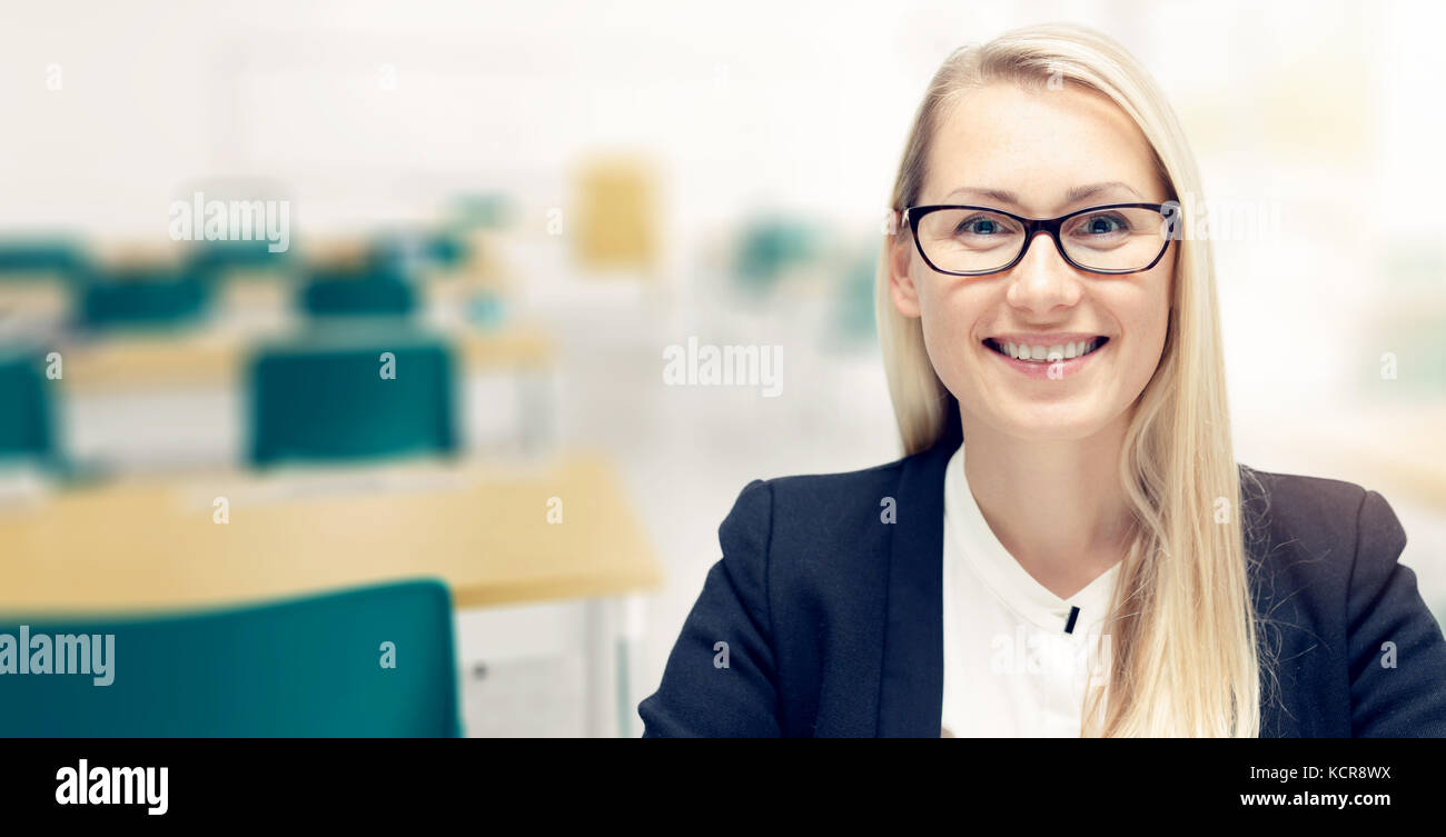 young smiling female teacher in classroom Stock Photo - Alamy