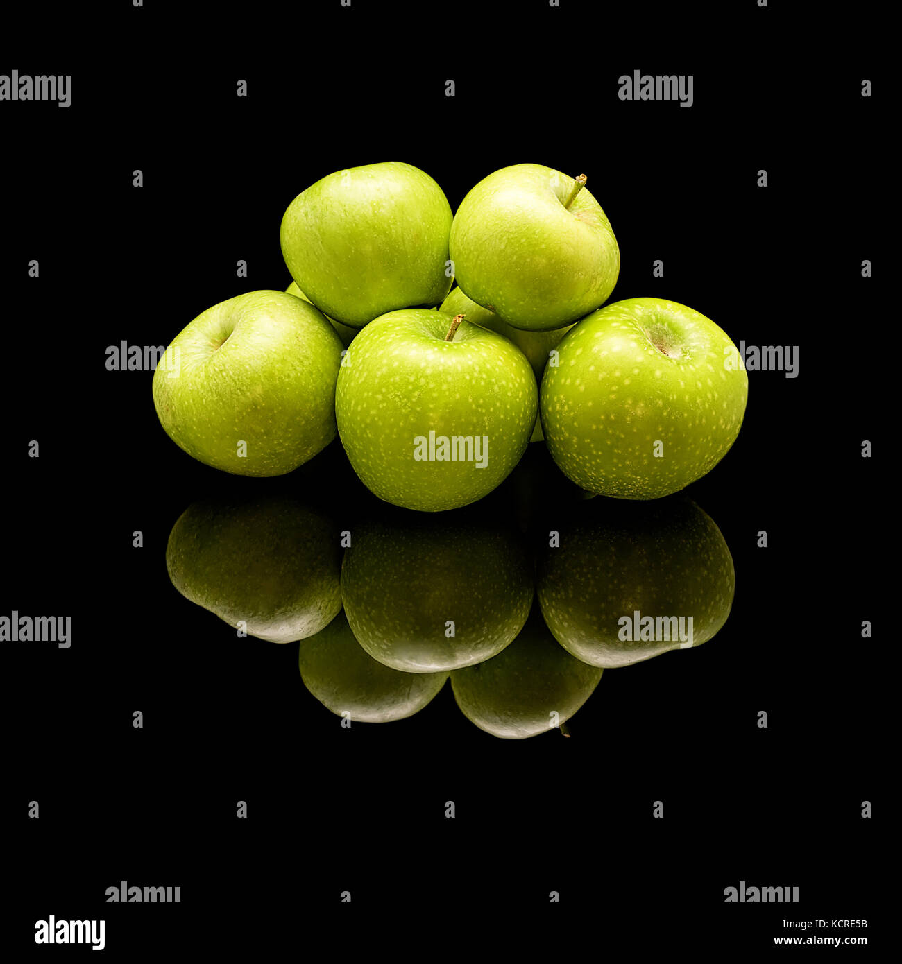 Bunch of green apples. On a black glossy background with real ...