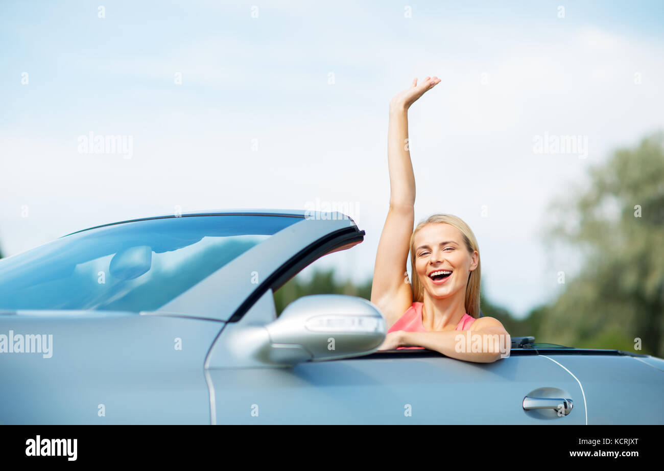 happy young woman in convertible car waving hand Stock Photo - Alamy