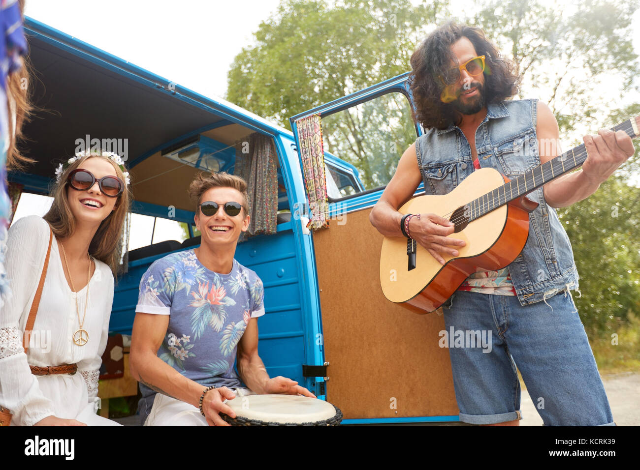happy hippie friends playing music in minivan Stock Photo - Alamy