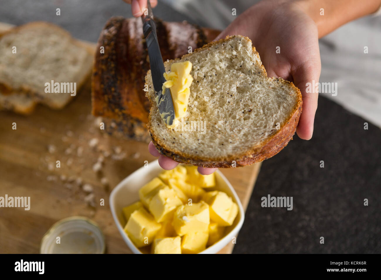 Close-up of woman applying butter over multigrain bread slice Stock ...