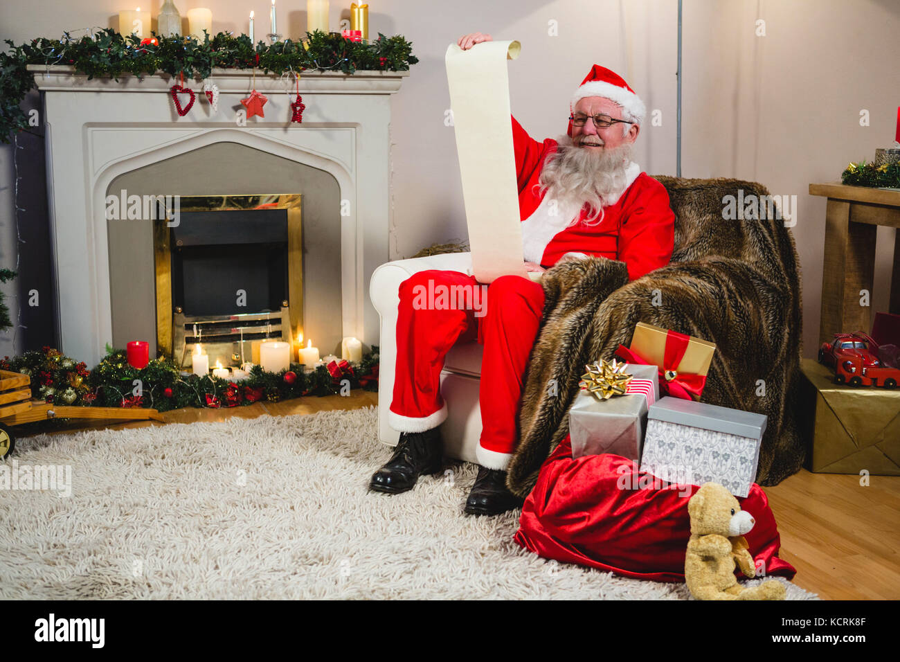Santa Claus reading scroll in living room at home Stock Photo - Alamy