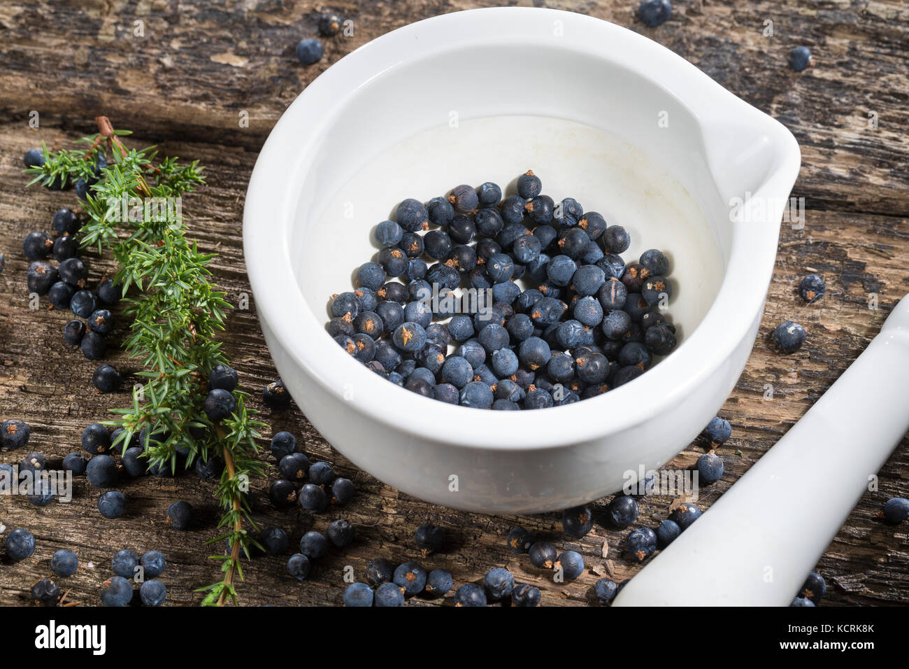 Wacholderbeeren, Wacholder-Beeren in einem Mörser, werden gemörsert ...