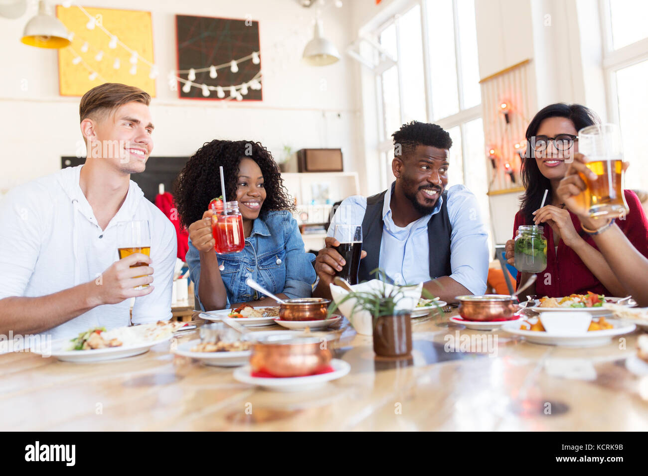 happy friends eating and drinking at restaurant Stock Photo - Alamy