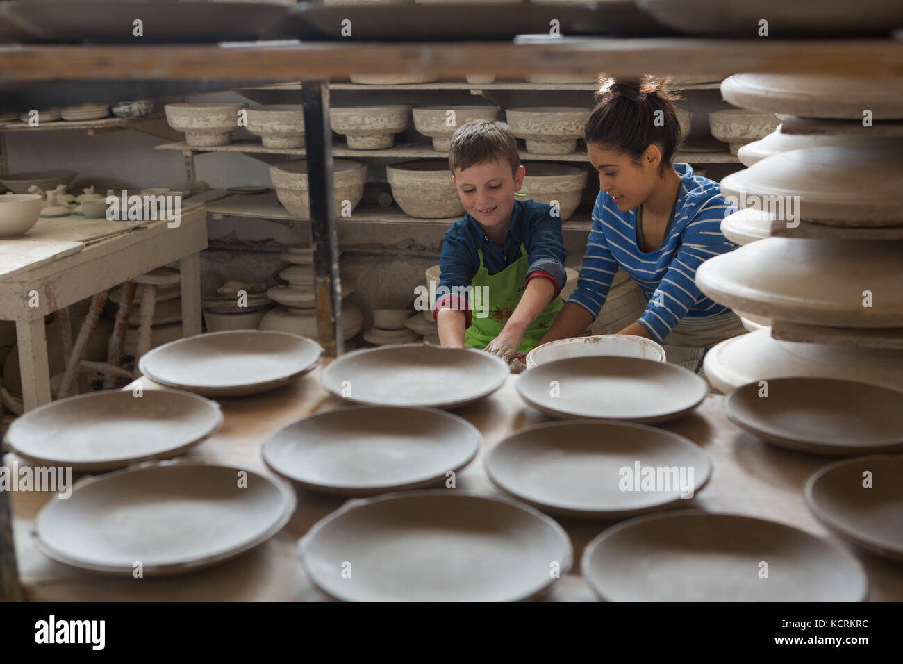Female potter assisting a boy in pottery workshop Stock Photo - Alamy