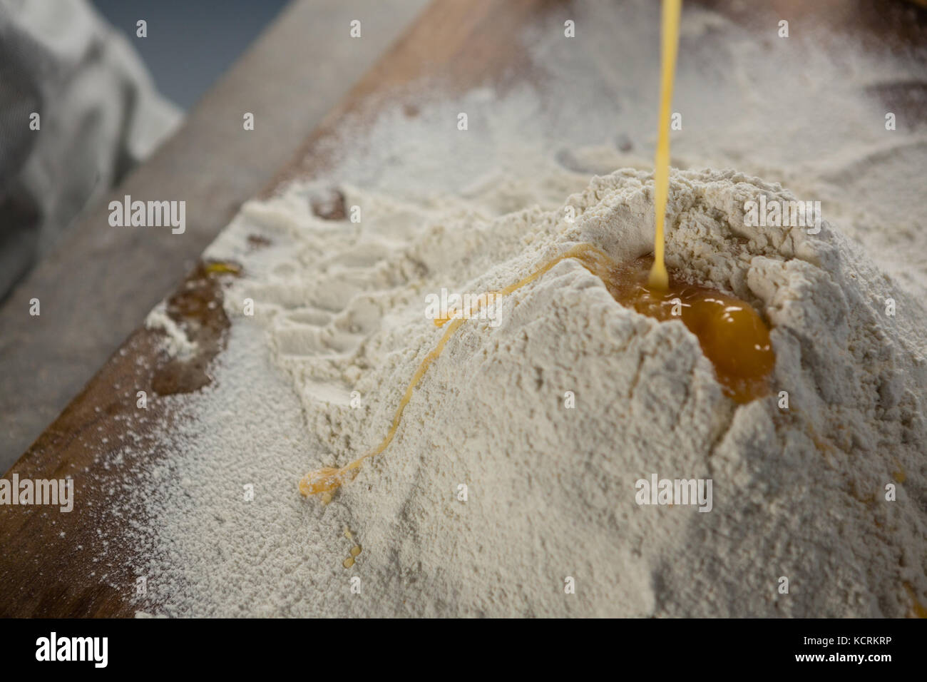 Close-up of liquid egg poured on flour Stock Photo - Alamy