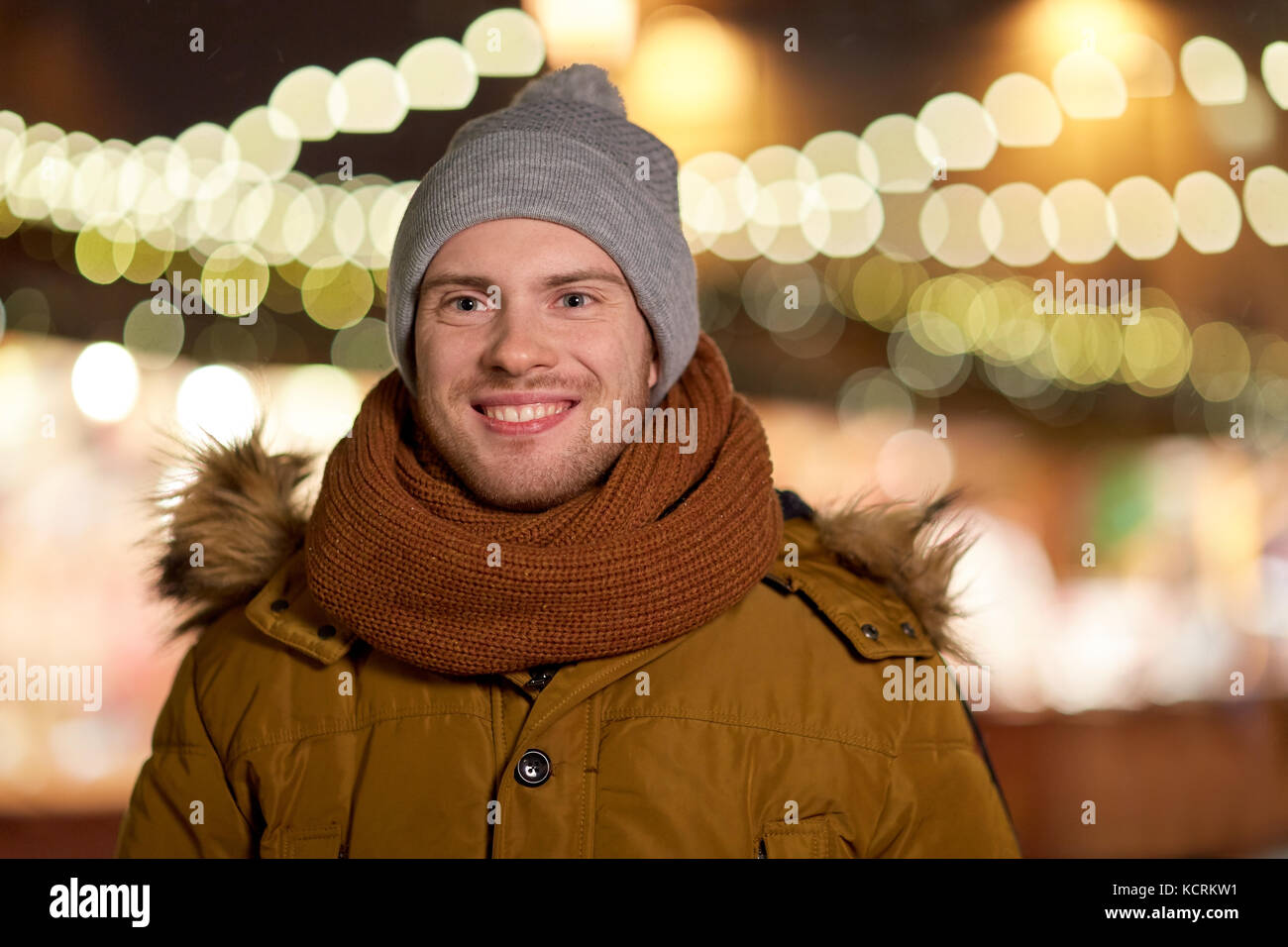 happy young man over christmas lights in winter Stock Photo - Alamy