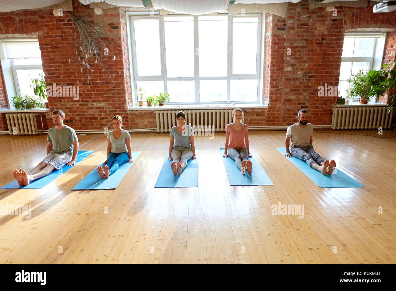 group of people doing yoga staff pose at studio Stock Photo - Alamy