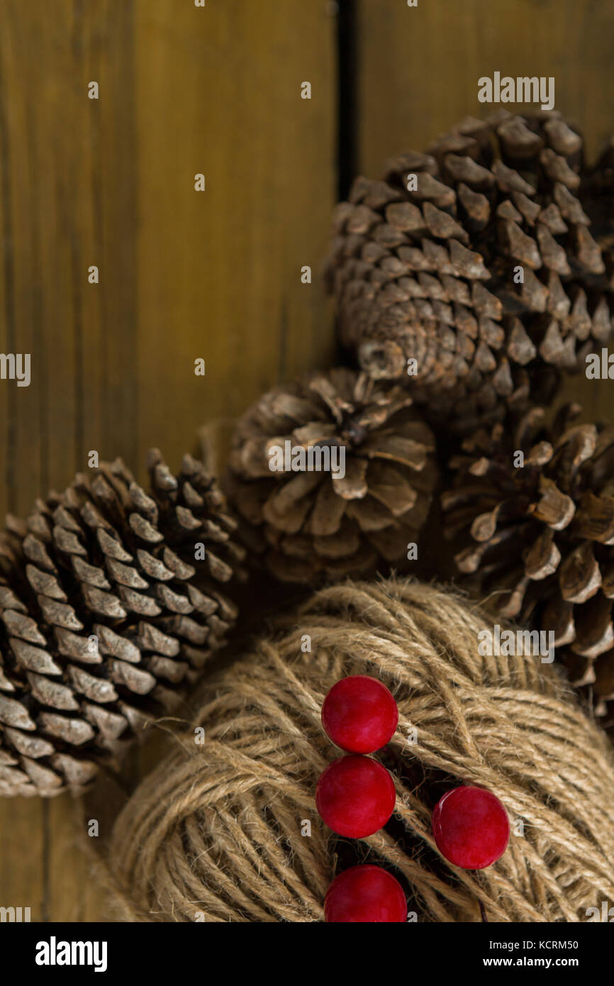 Directly above of pine cones with thread spool with push pin on table ...