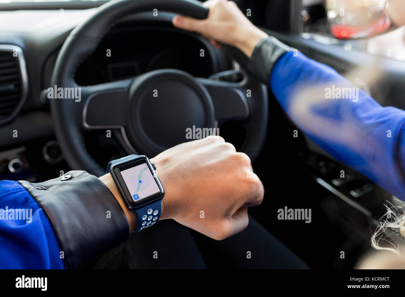 High angle view of woman wearing smart watch in car during test drive ...