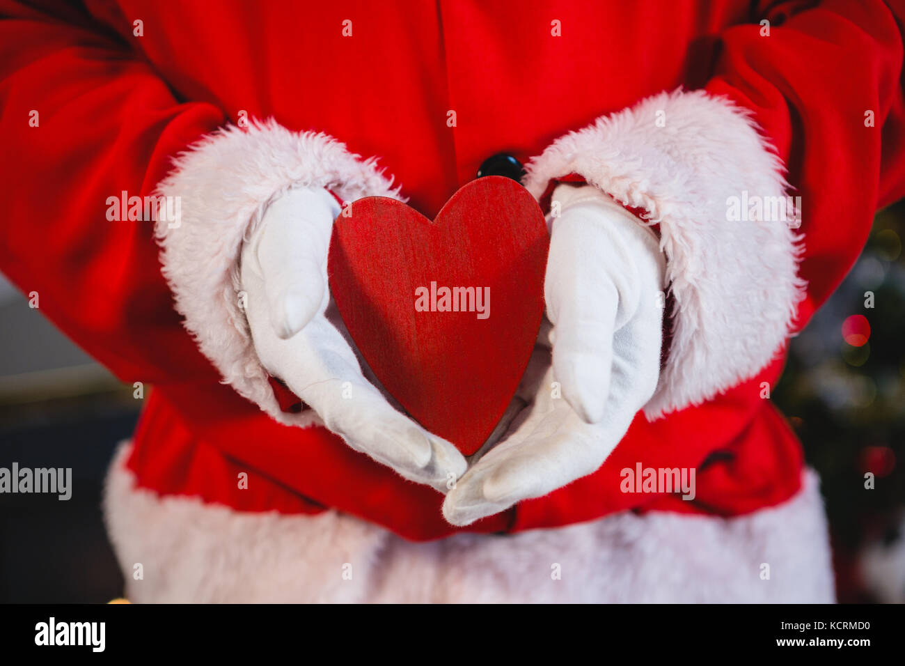 Mid-section of santa claus holding a heart Stock Photo - Alamy