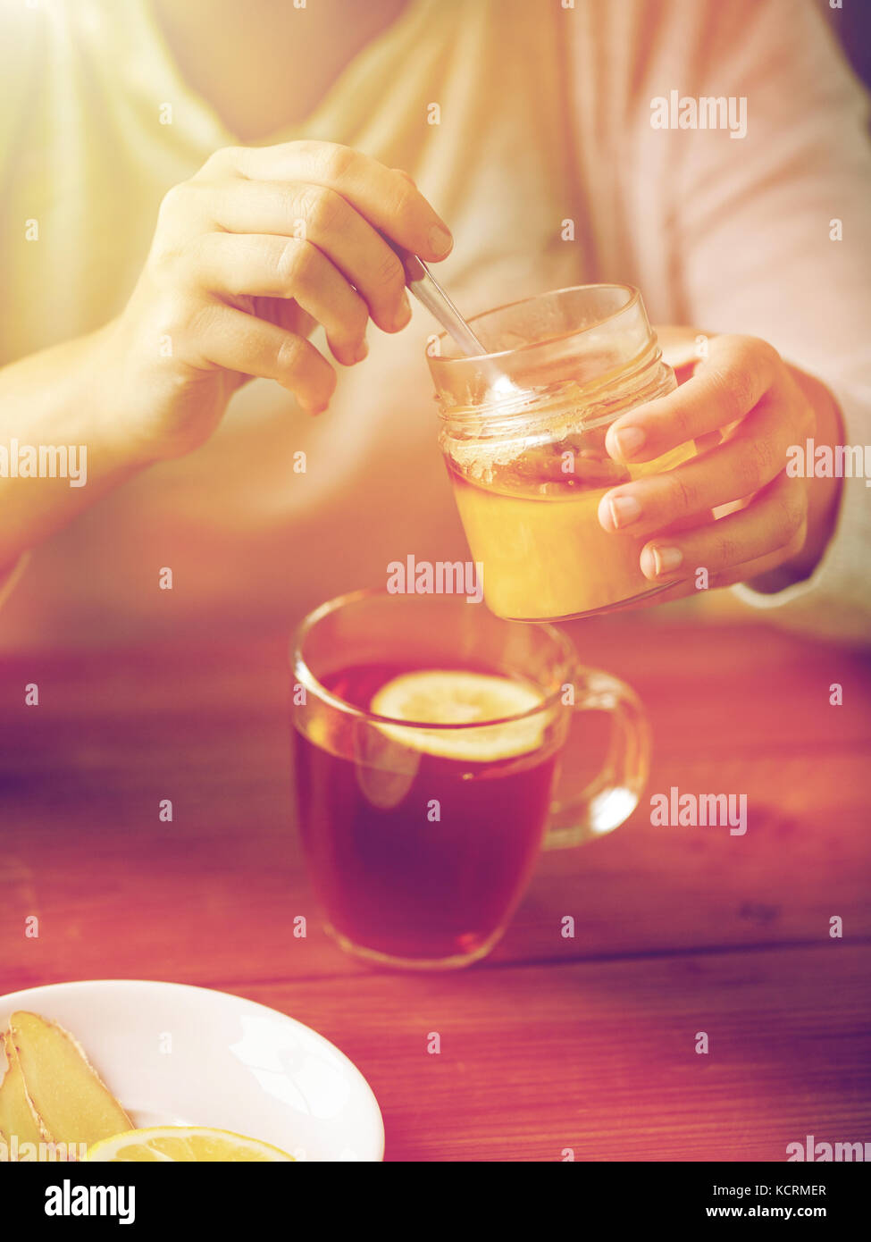 close up of woman adding honey to tea with lemon Stock Photo - Alamy