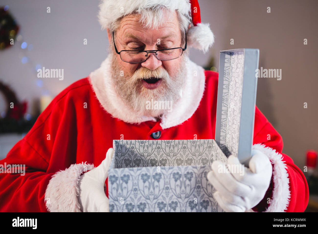 Surprise santa claus opening a gift box in living room Stock Photo - Alamy