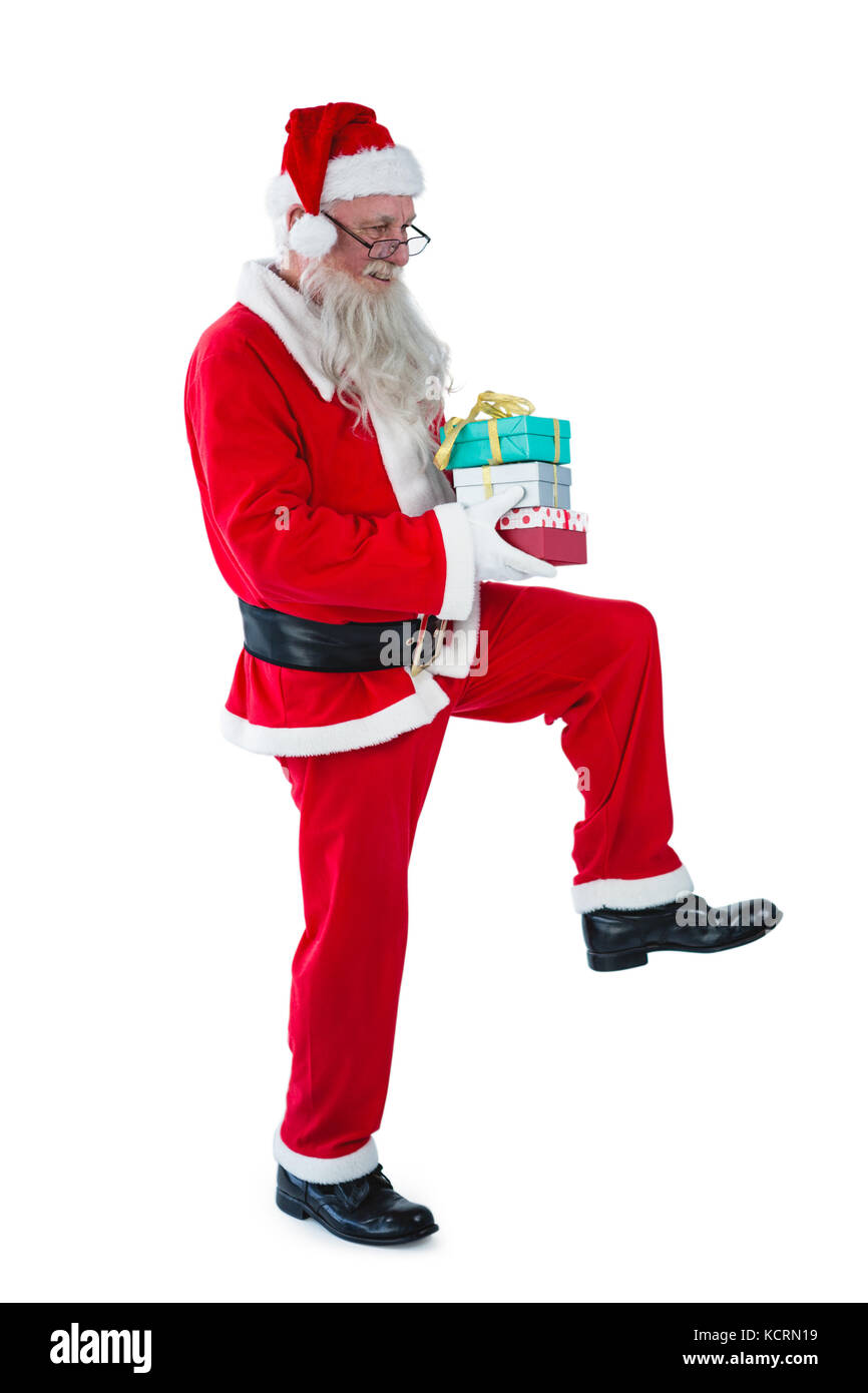 Santa Claus holding gift boxes against white background Stock Photo - Alamy
