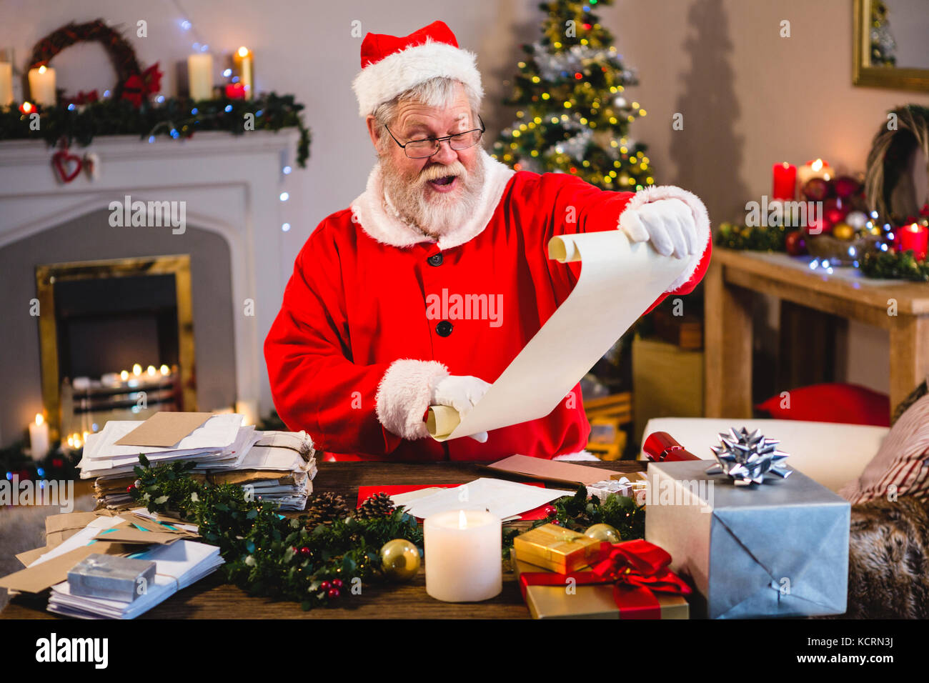 Santa Claus reading scroll in living room at home Stock Photo - Alamy