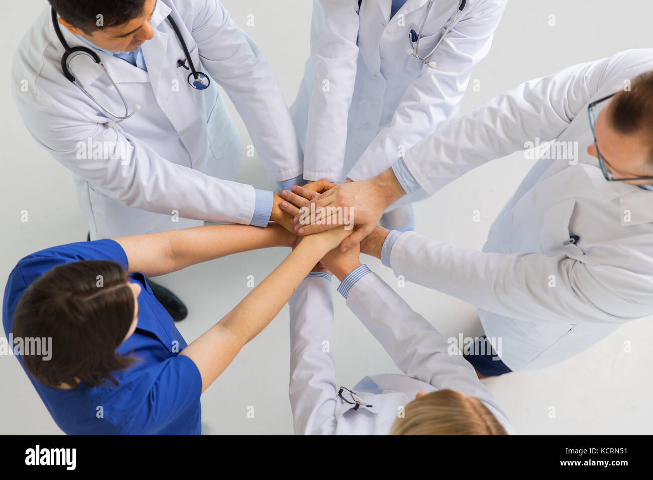 group of doctors with hands together at hospital Stock Photo - Alamy
