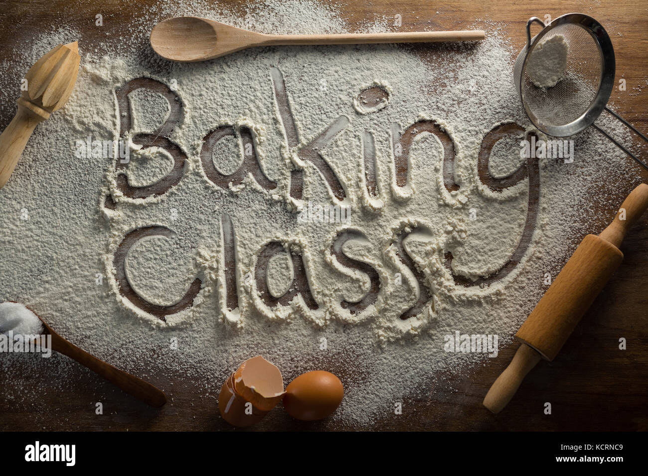 Over head view of the word baking class written on sprinkled flour ...